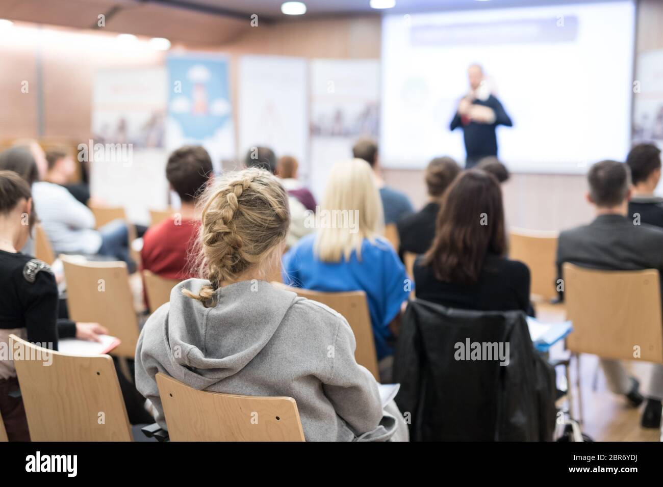 Audience at the conference hall. Speaker giving a talk in conference ...