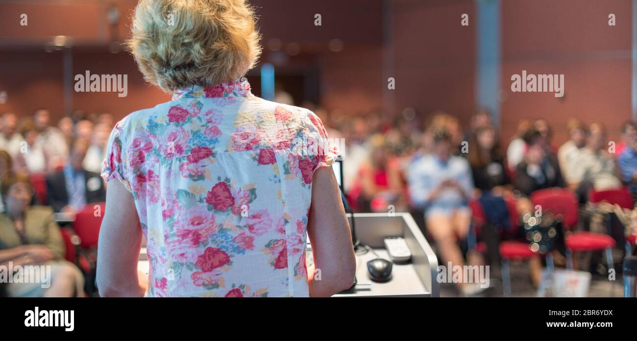 Female academic professor lecturing at Conference. Audience at the ...