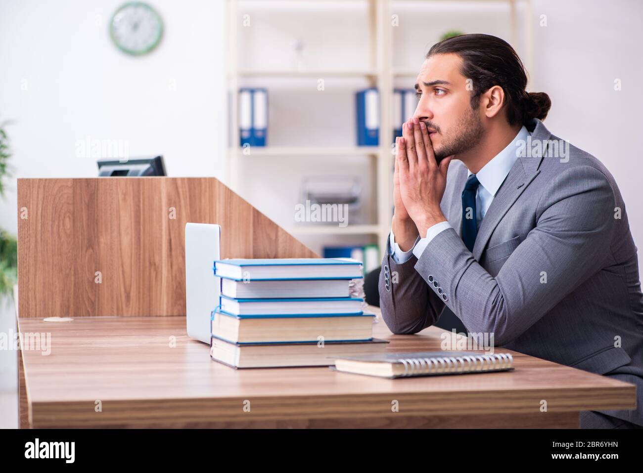 Young businessman reading books at workplace Stock Photo - Alamy