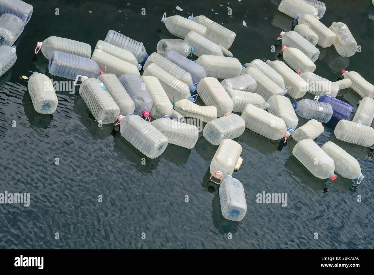 Empty large plastic containers, water cans floating in a bay in the ...