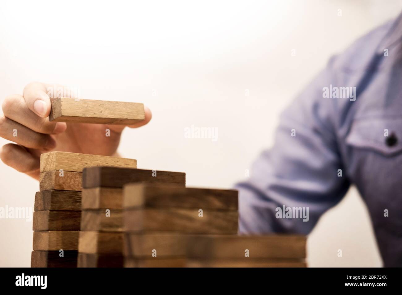 Business man hand put wooden blocks arranging stacking for development ...