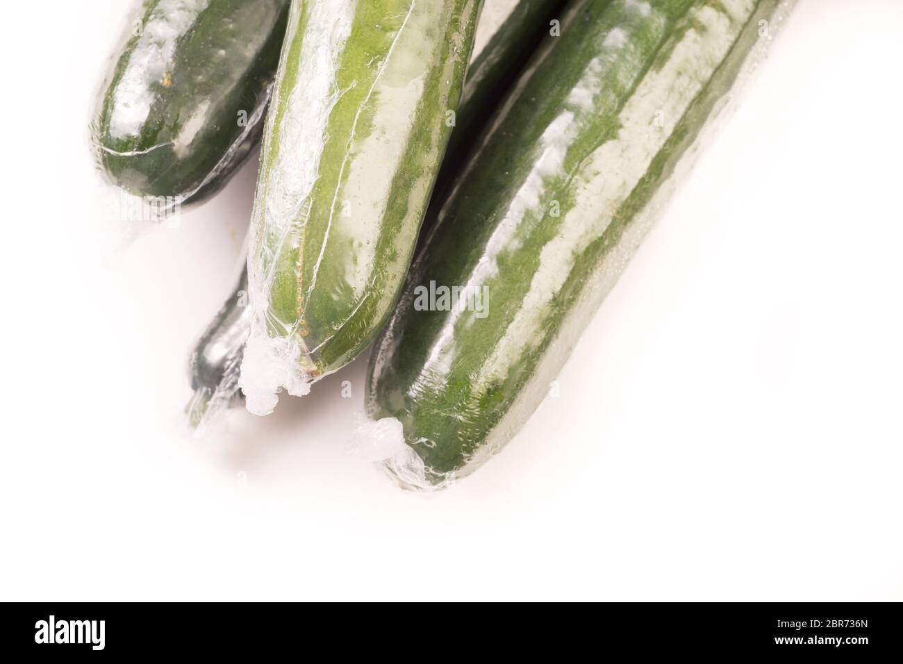Bunch of cucumber wrapped in plastic films, isolated on white ...