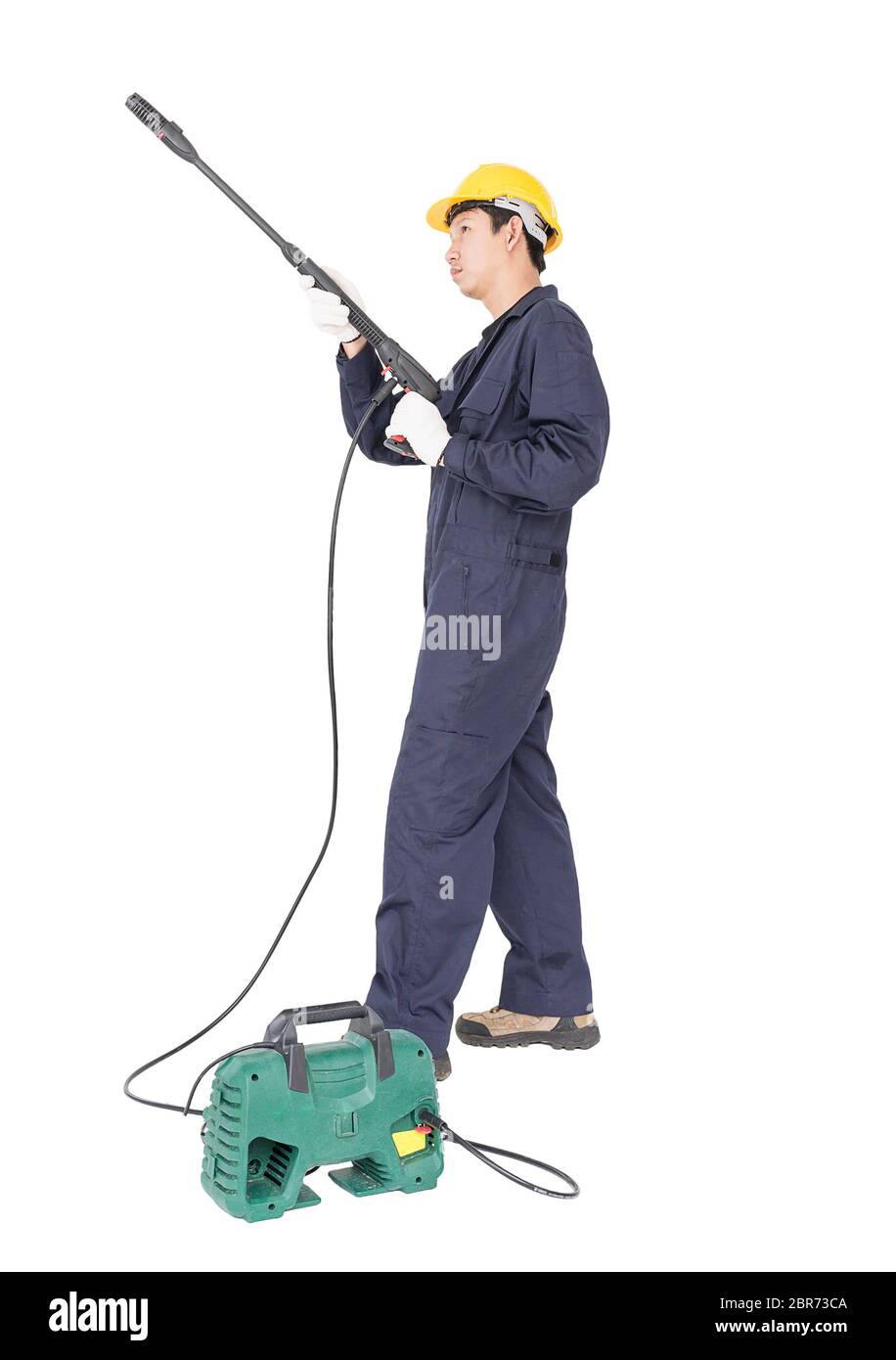 Young man in uniform stand and holding high pressure water gun portable ...