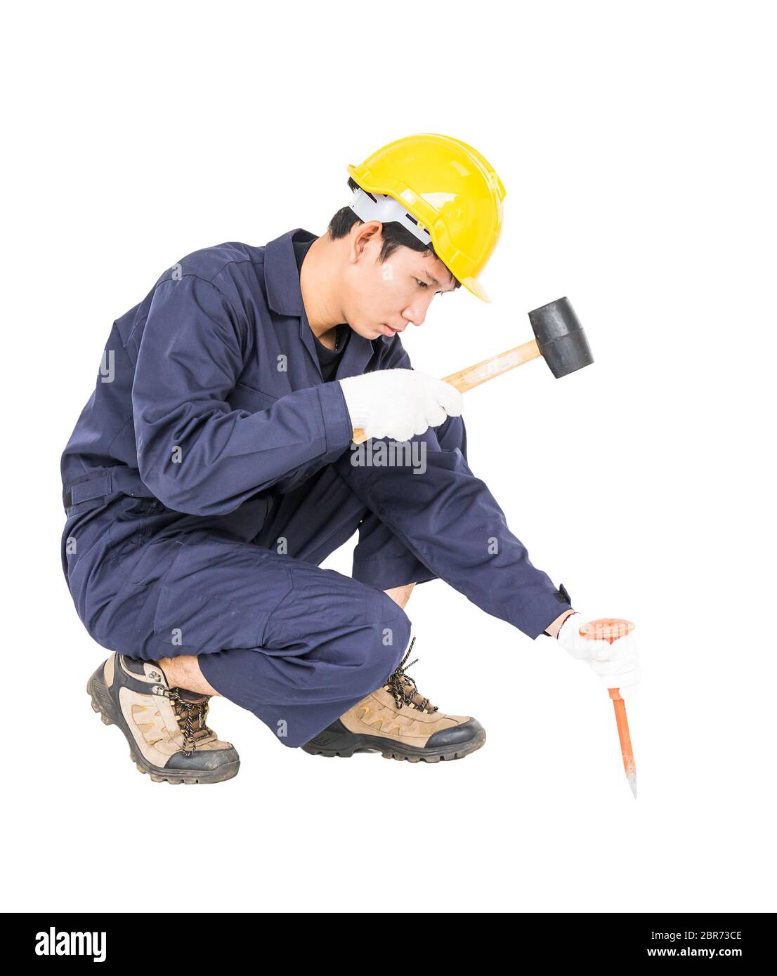 Young man in uniform sit and holding hammer was nailed to a cold chisel ...