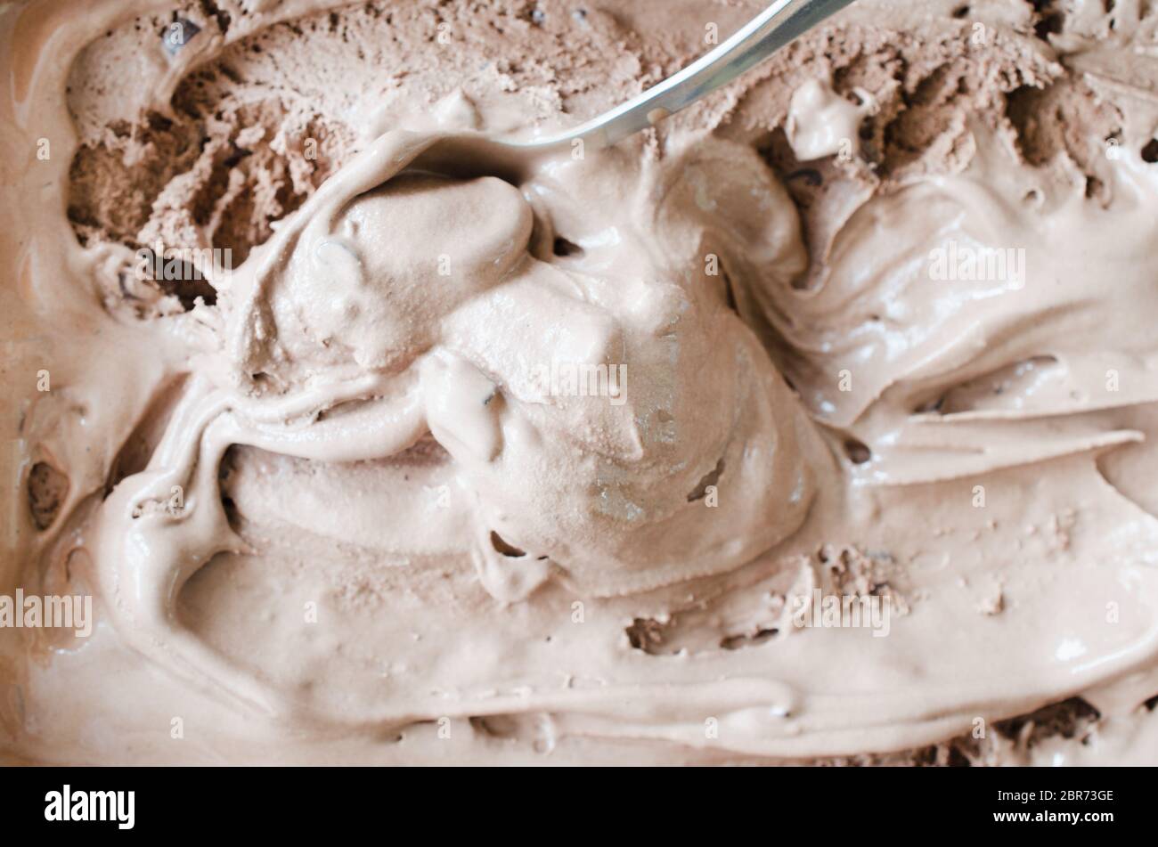 Texture of melting chocolate ice cream. Brown background, close up ...