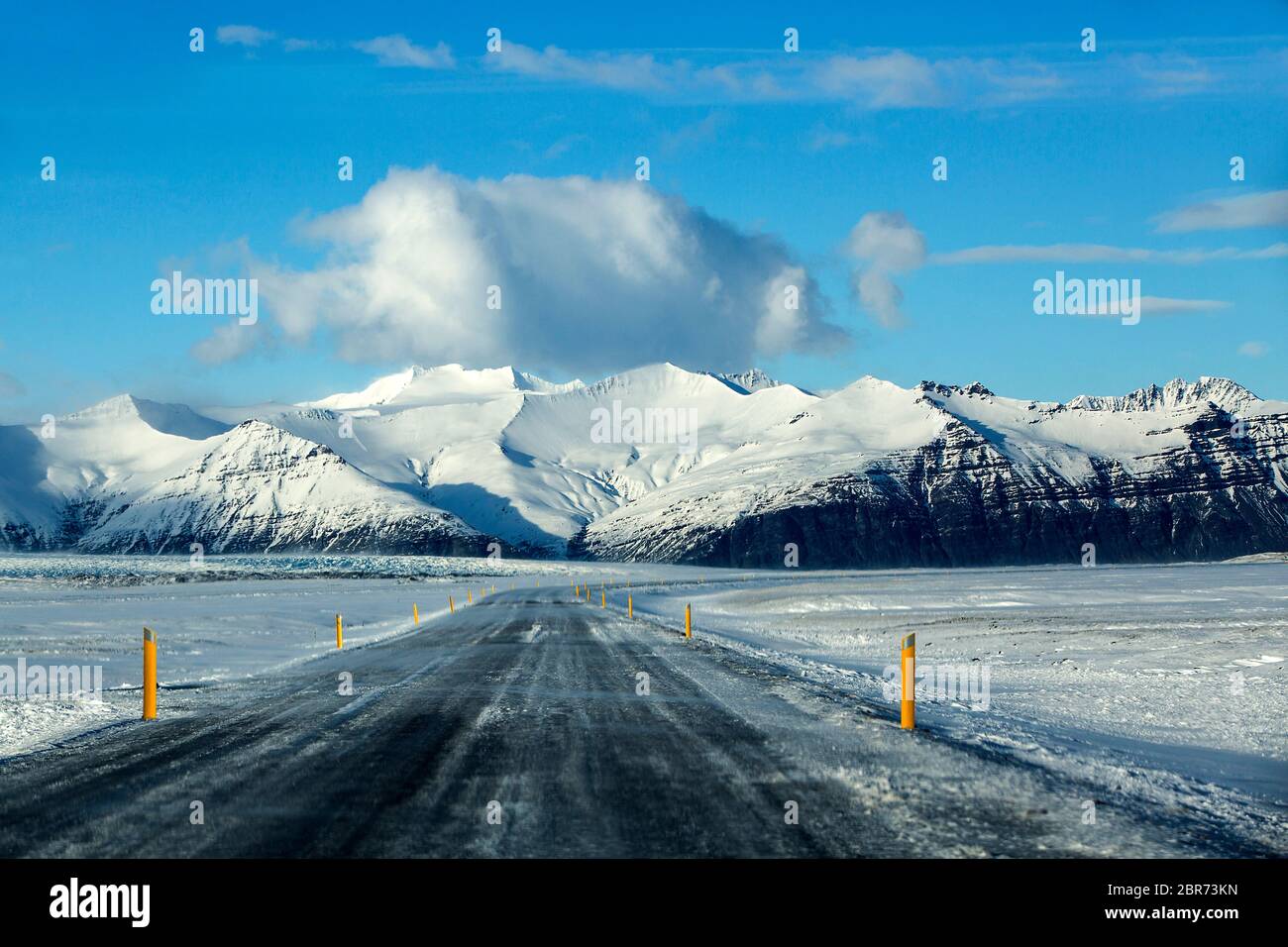 Snowy road with volcanic mountains in wintertime, Iceland Stock Photo ...