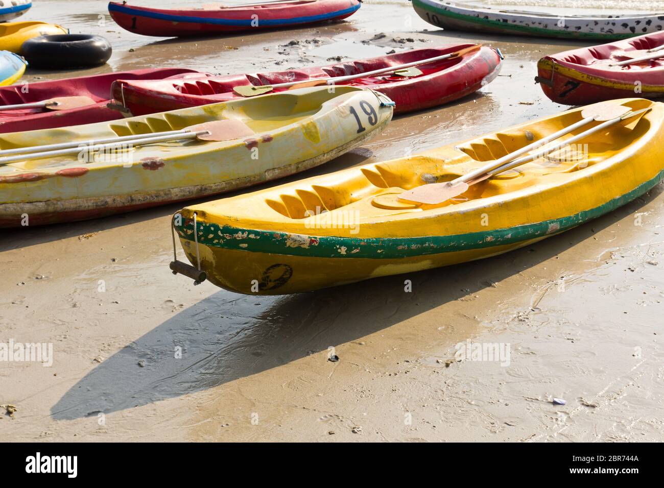 Old Colourful kayaks on the beach Stock Photo - Alamy