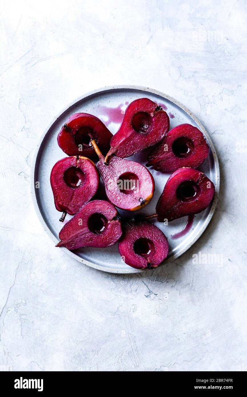 Red wine poached pears cut in half Stock Photo - Alamy