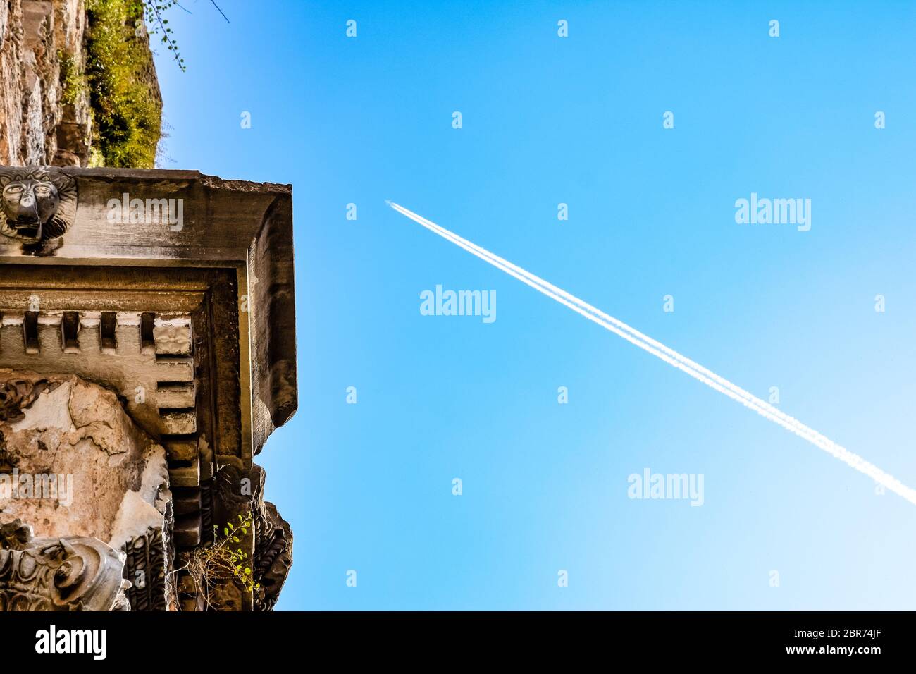The plane leaving a condensation trail flies high above the gates of ...