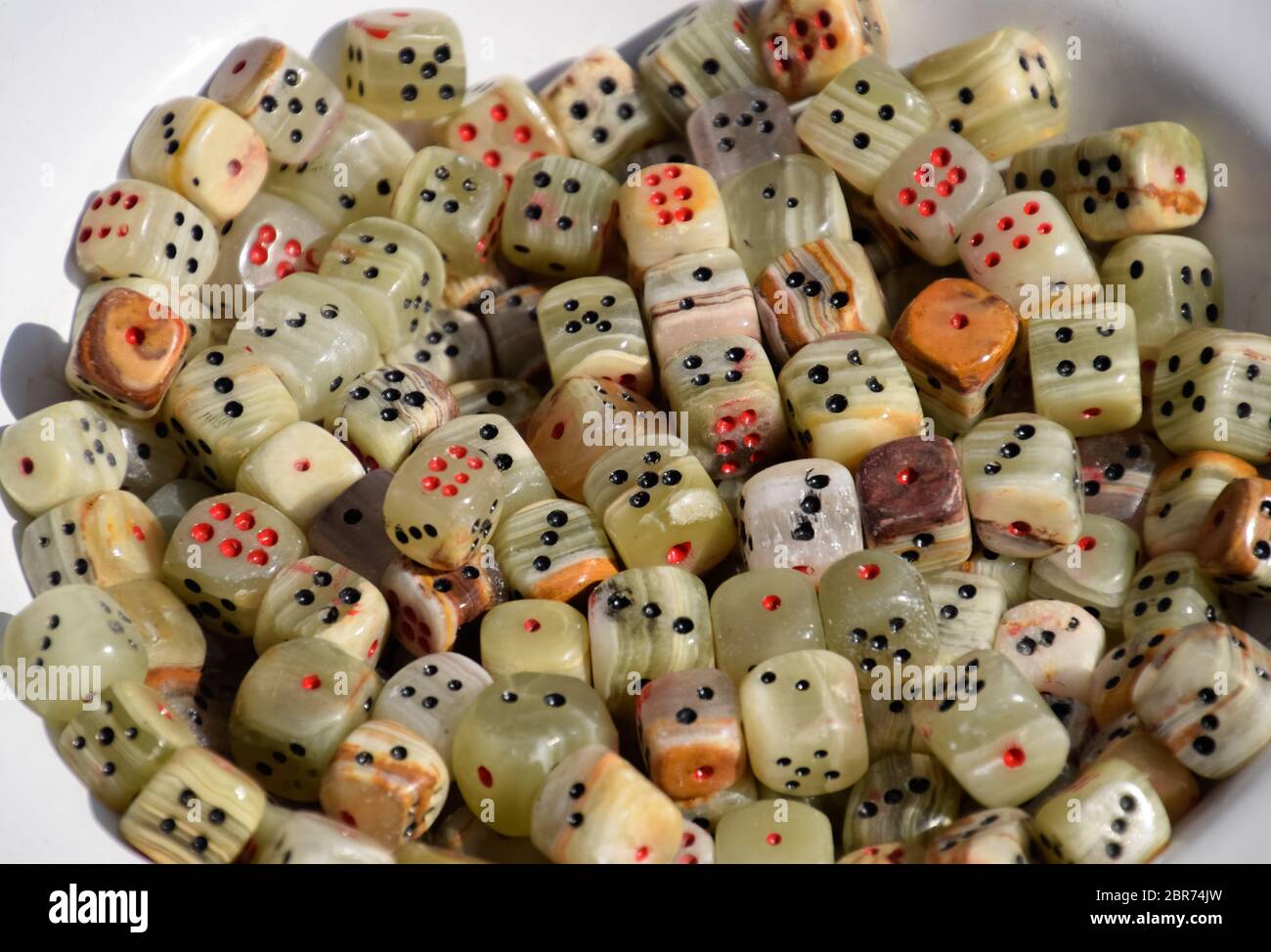 Dice made of green stone. Bowl with dices Stock Photo - Alamy