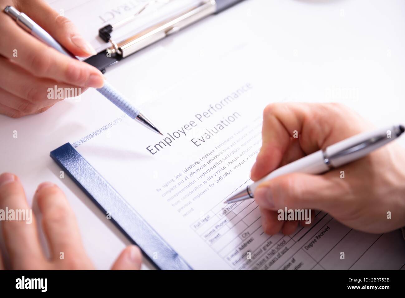 Close-up Of A Person Filling Performance Evaluation Form Of Employee ...
