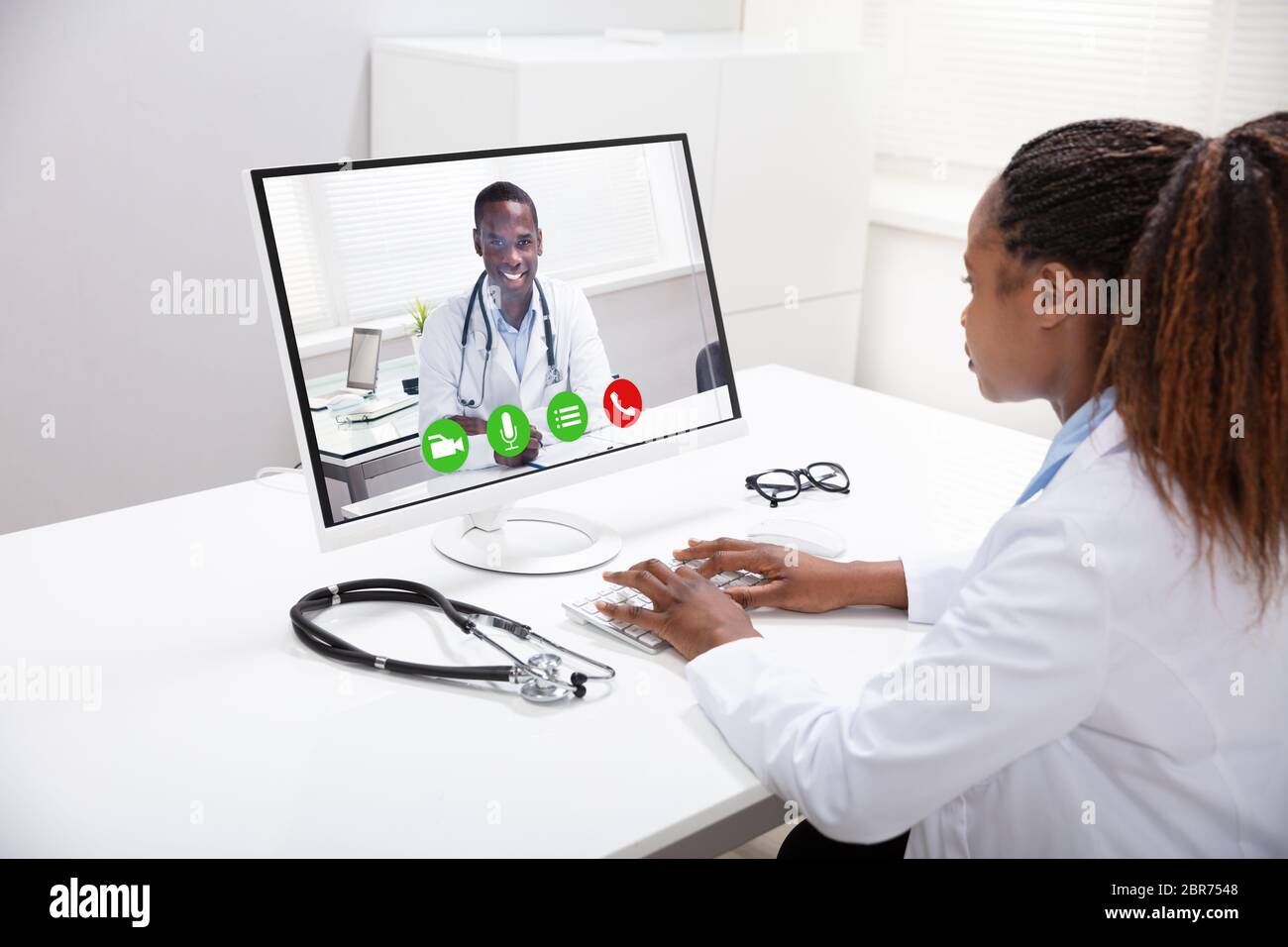 Female Doctor Video Conferencing With Happy Male Colleague On Computer ...