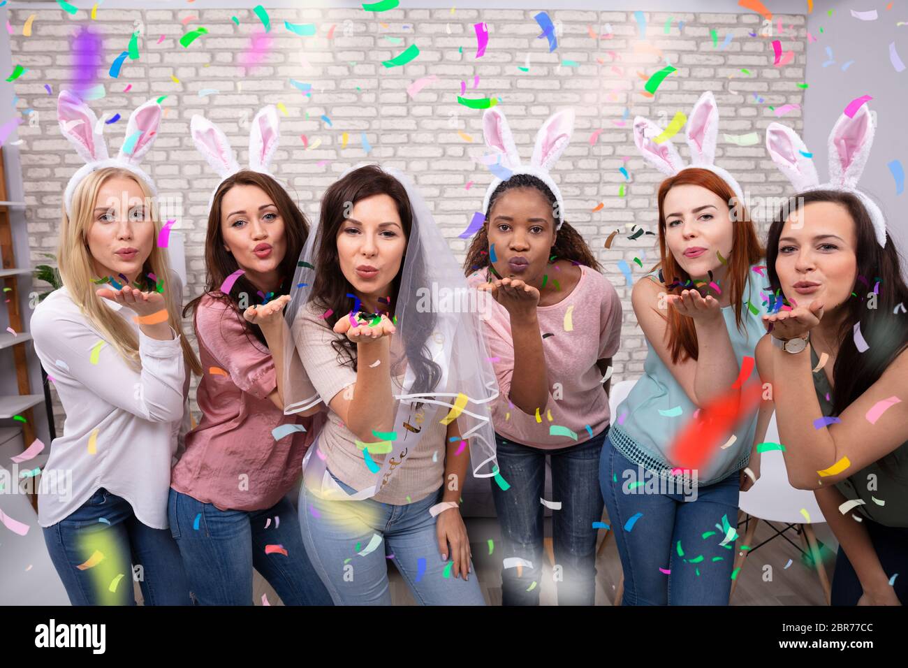 Close-up Of Attractive Female Friends Blowing Paper Confetti Towards ...