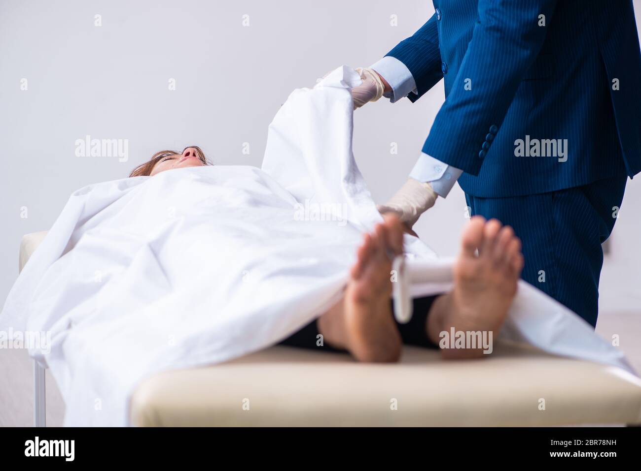 Police coroner examining dead body in morgue Stock Photo - Alamy