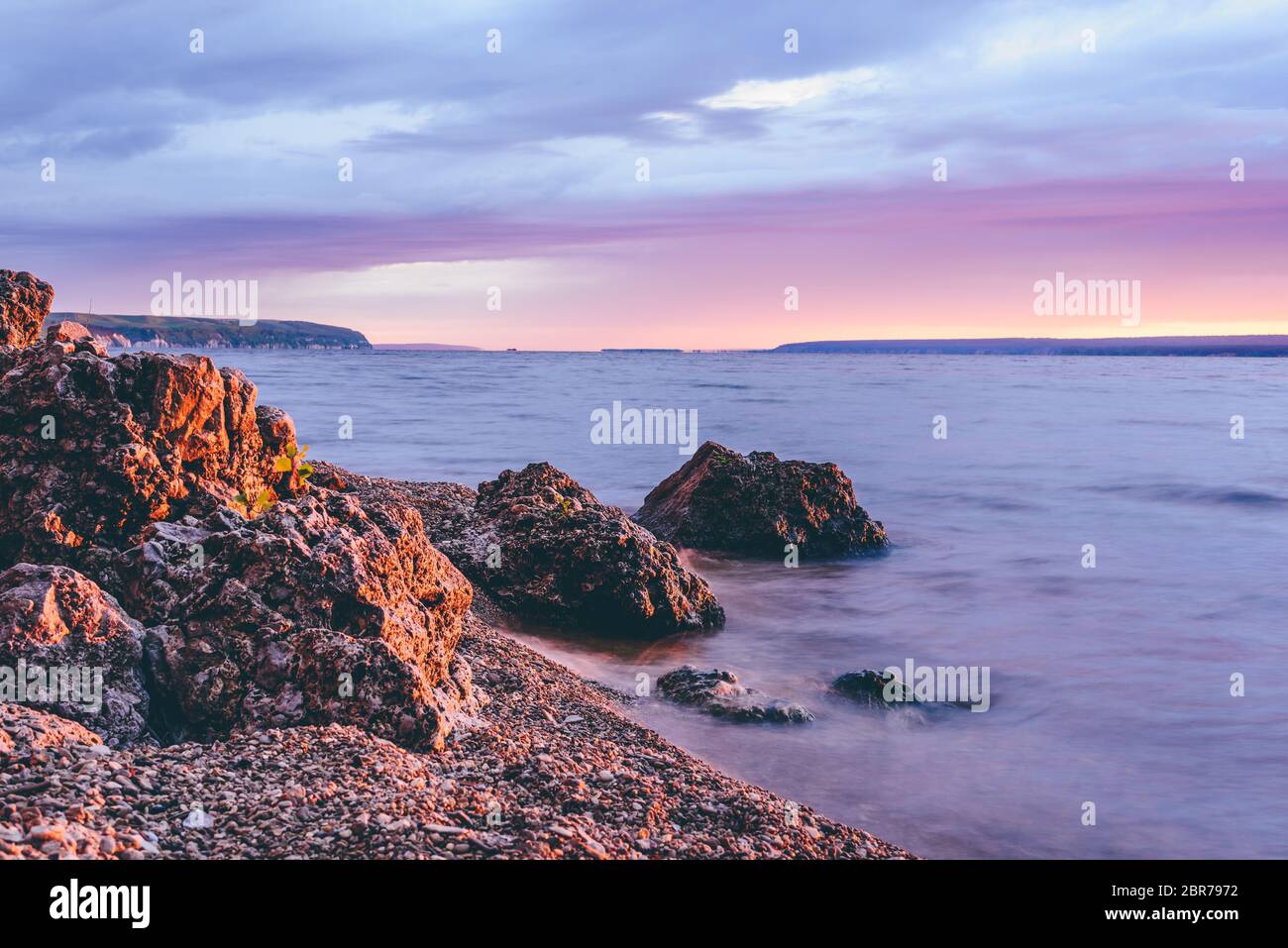 Boulders on the riverbank in sunrise light Stock Photo - Alamy
