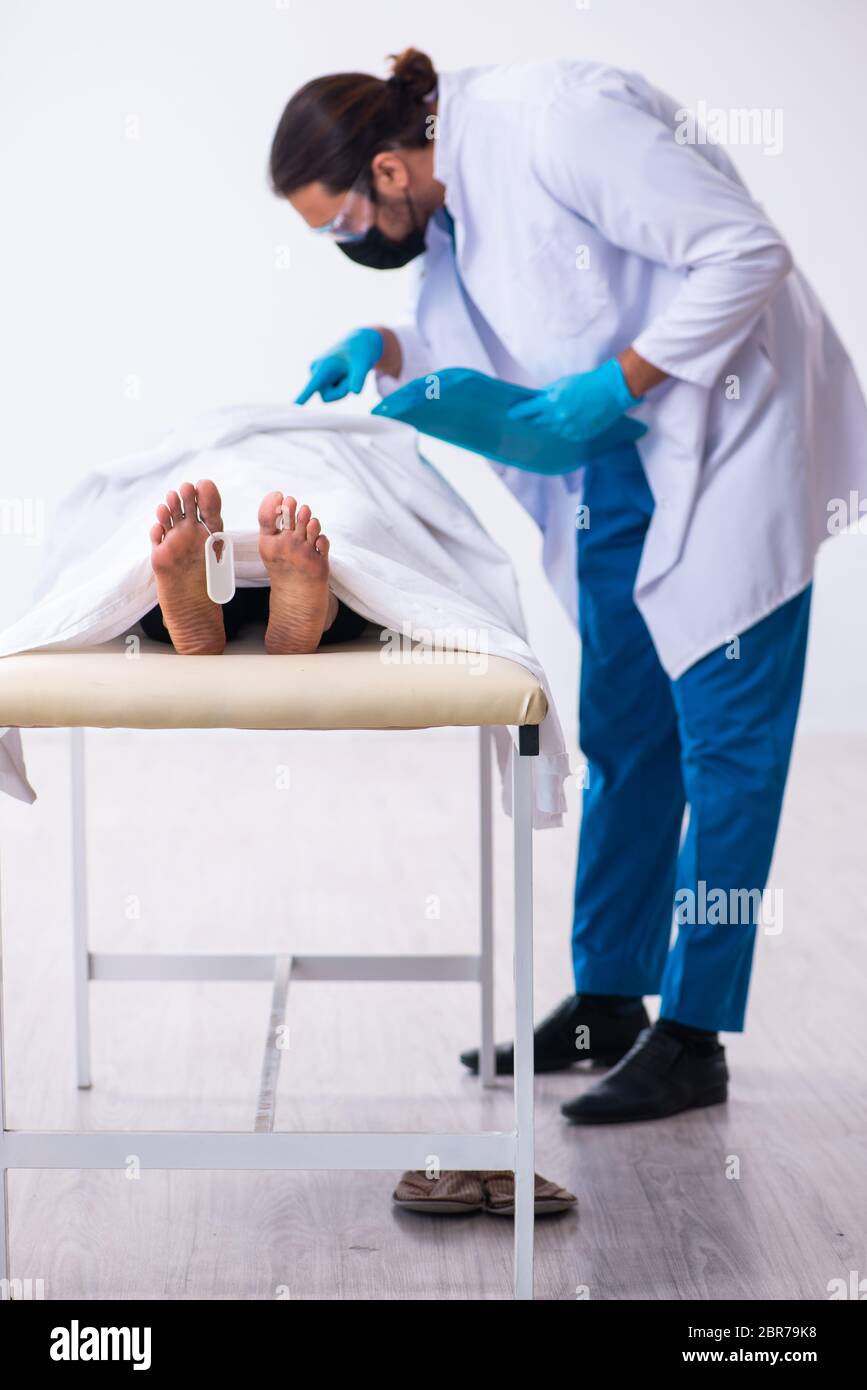 Police coroner examining dead body in morgue Stock Photo - Alamy