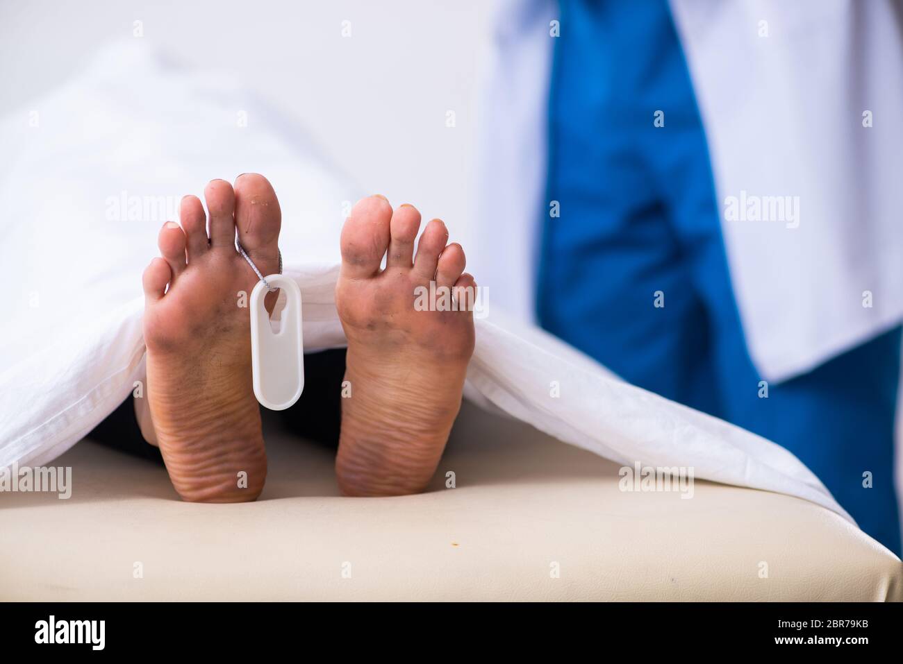 Police coroner examining dead body in morgue Stock Photo - Alamy