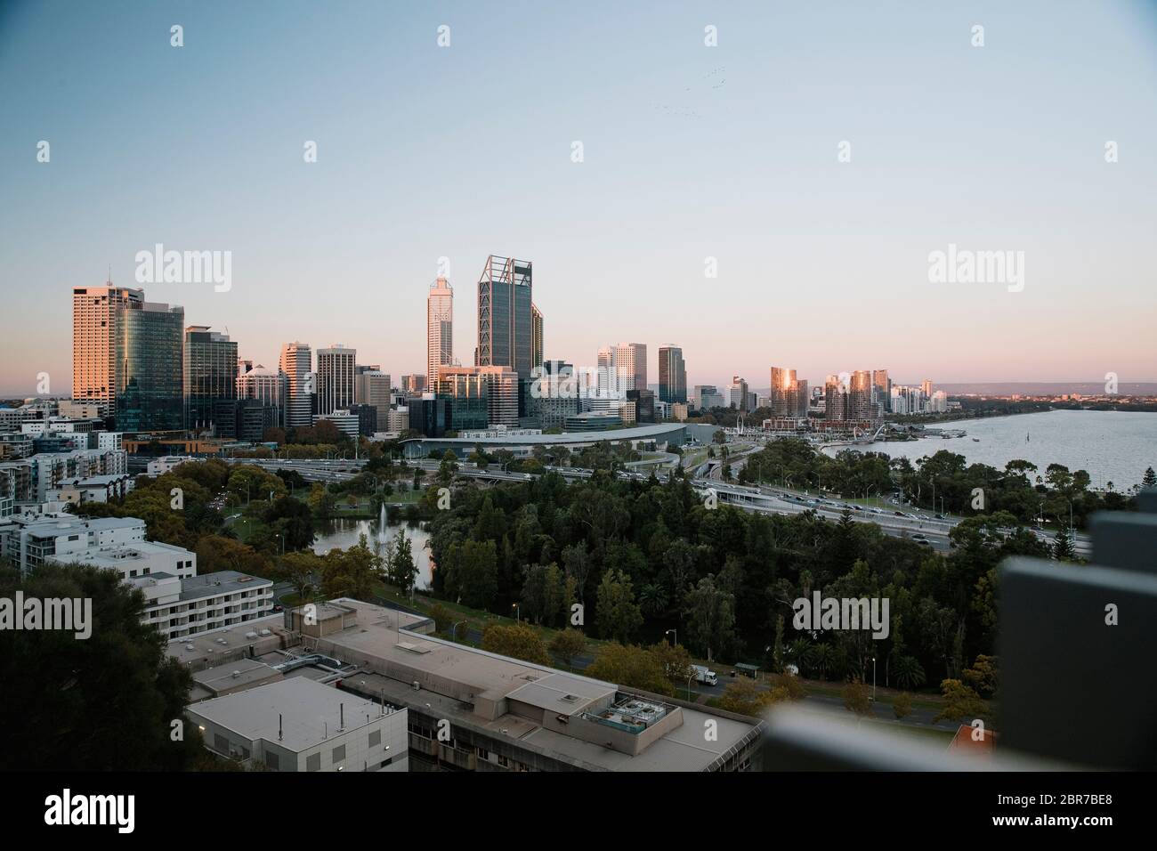 Wide shot of Perth's skyline at dusk with Swan River and natural ...