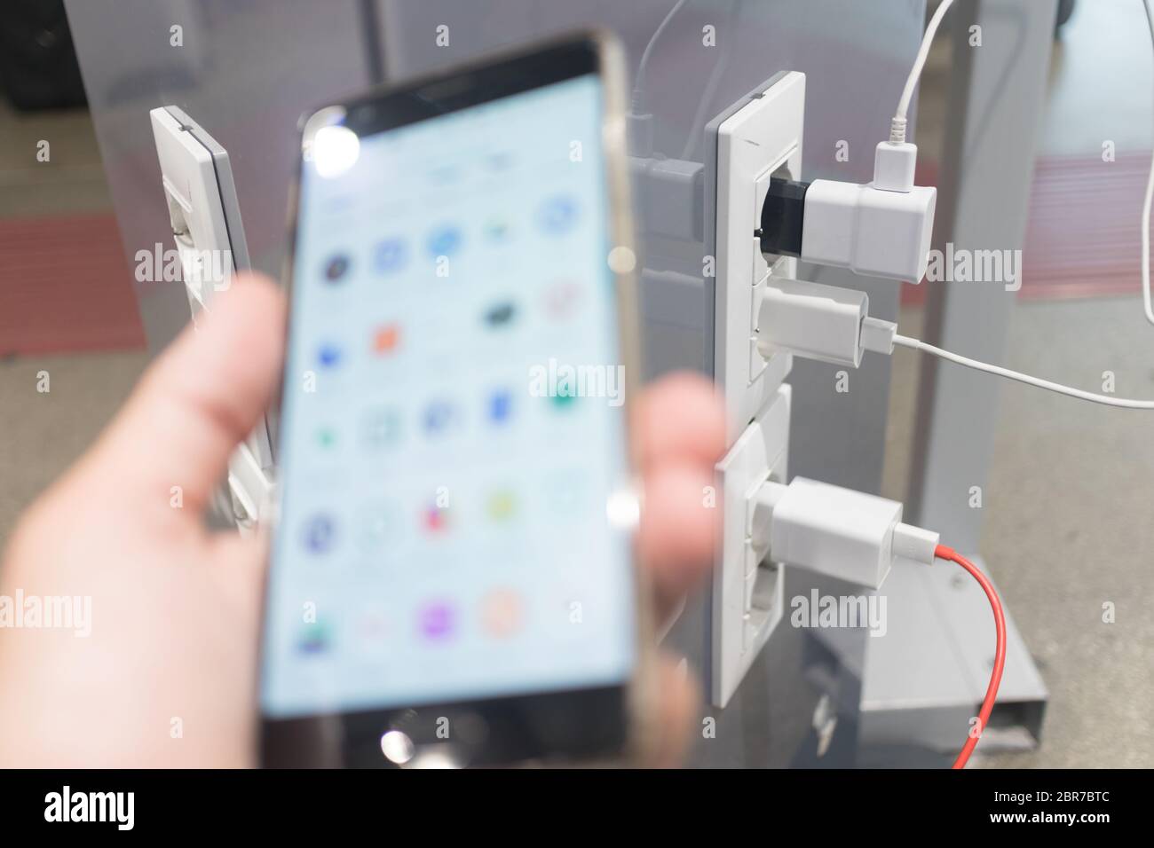 Female hands holding phone and using smartphone apps while charging it ...