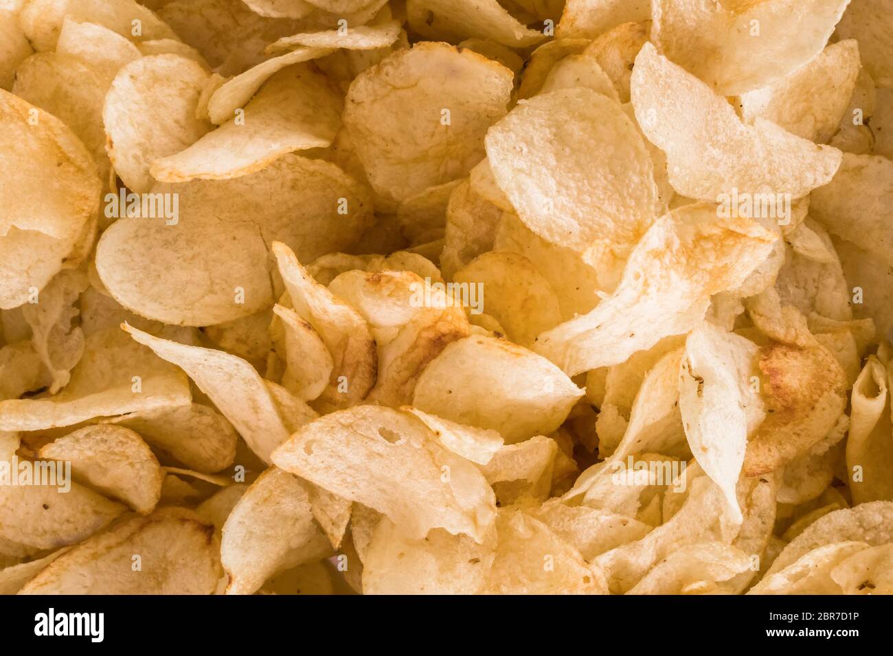 Crispy chips golden pattern. Yellow salted potato chips as background ...