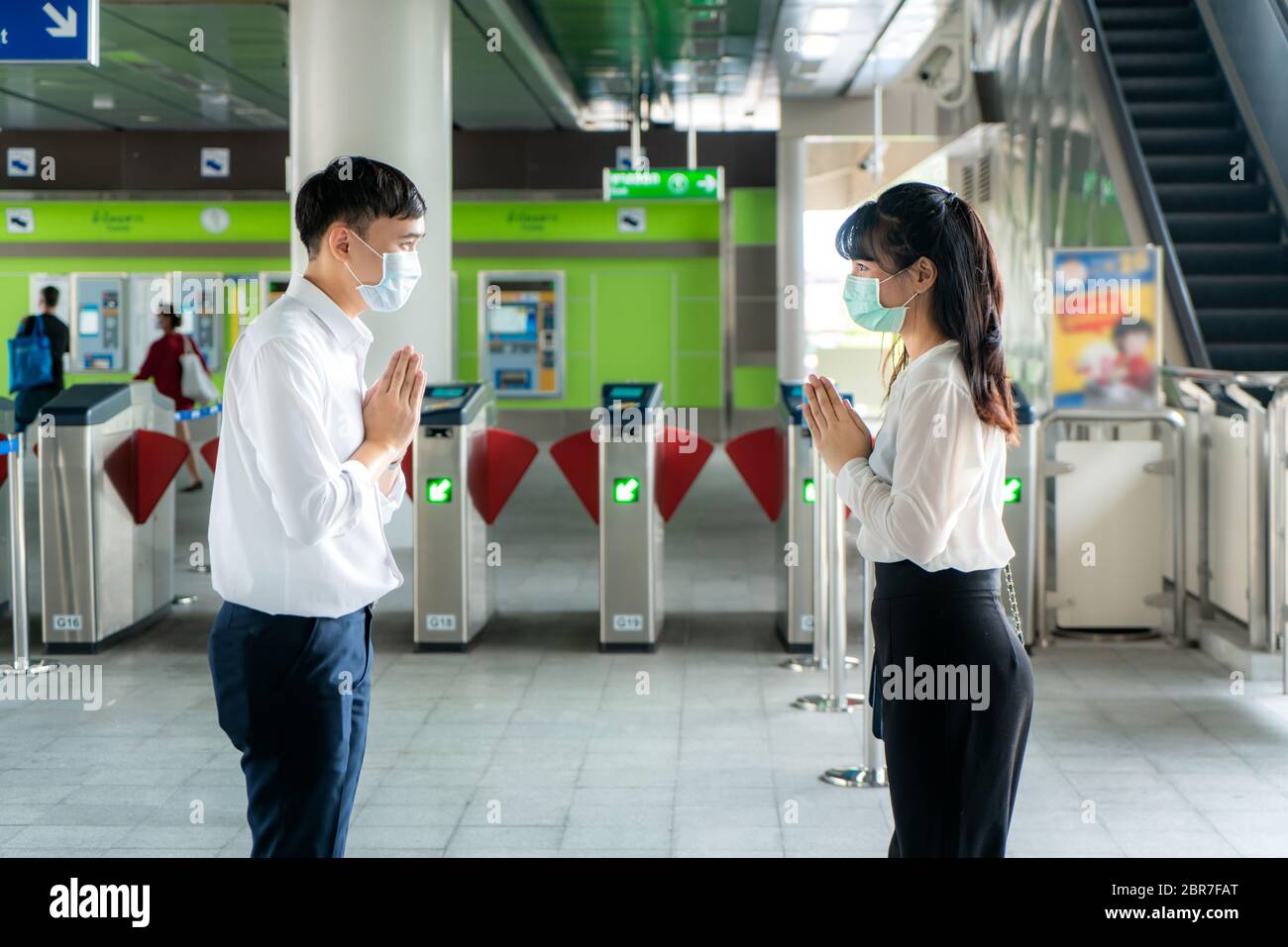 Two Asian business friends meet in subway station at city and geeting ...