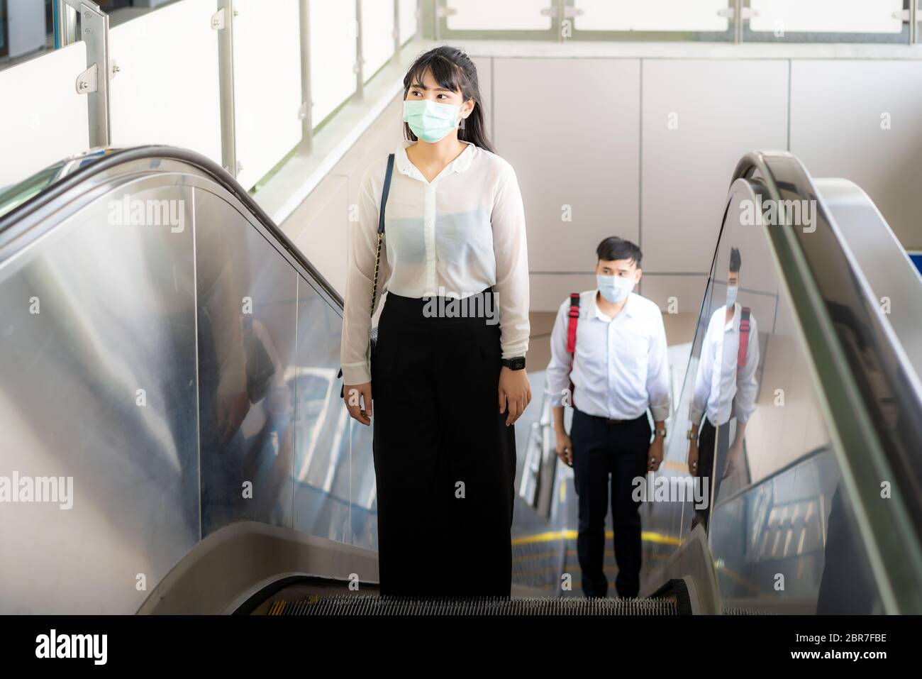 Two Asian wearing face mask and keep distance 6 feet to other people ...