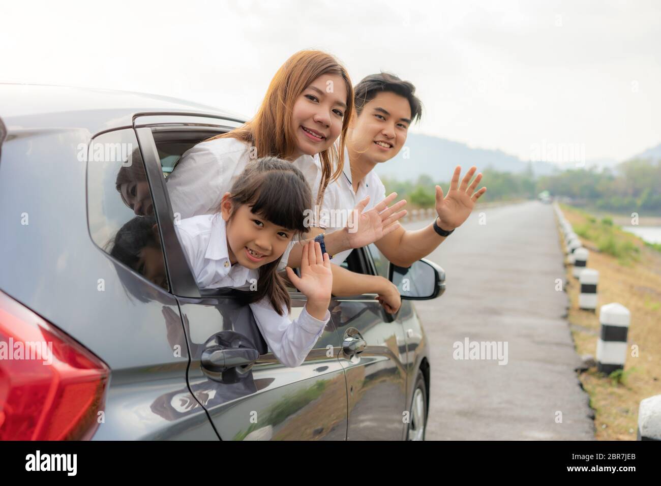 Happy Asian family with father, mother and daughter in compact car are ...