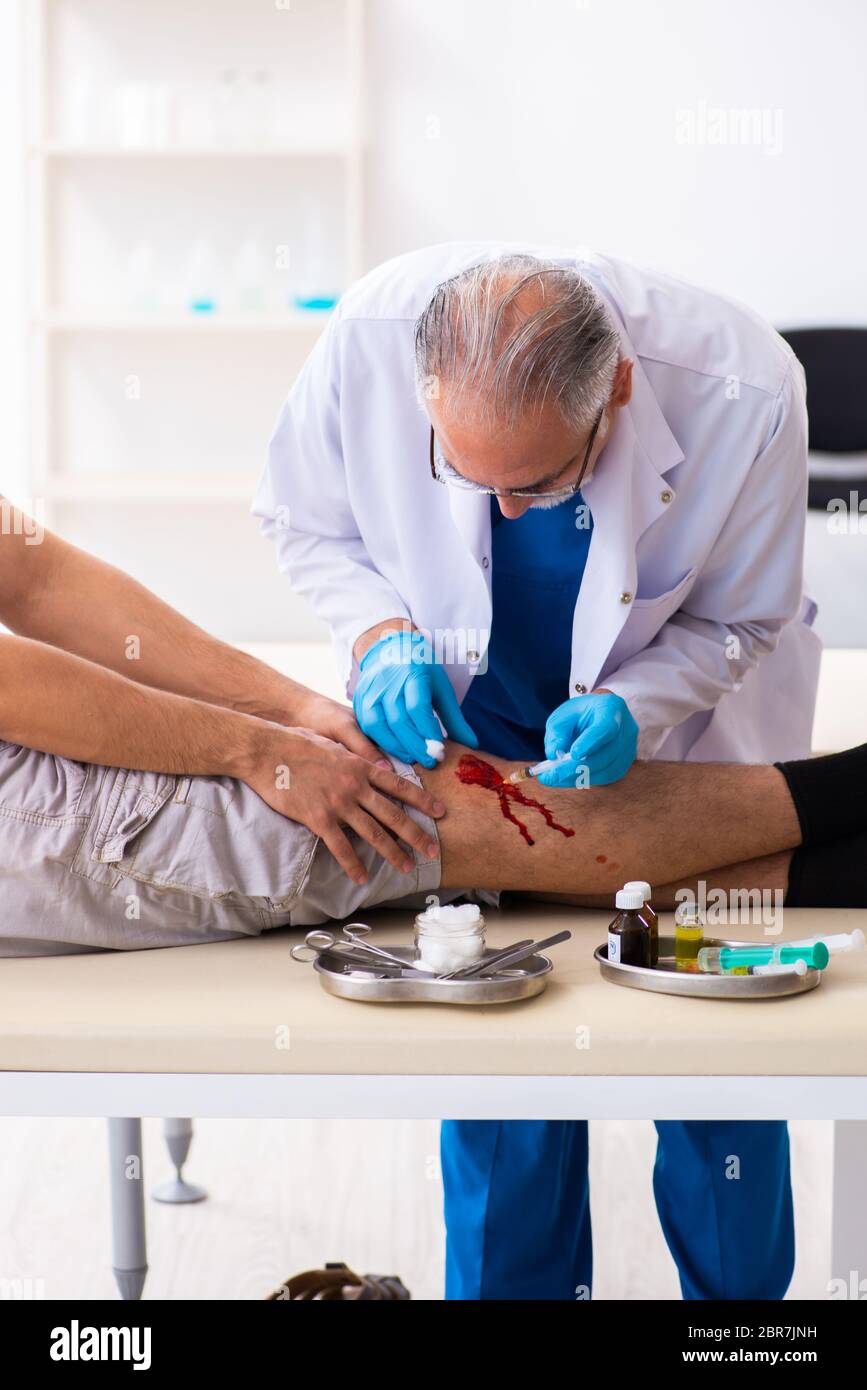 Leg injured man visiting doctor in first aid concept Stock Photo - Alamy