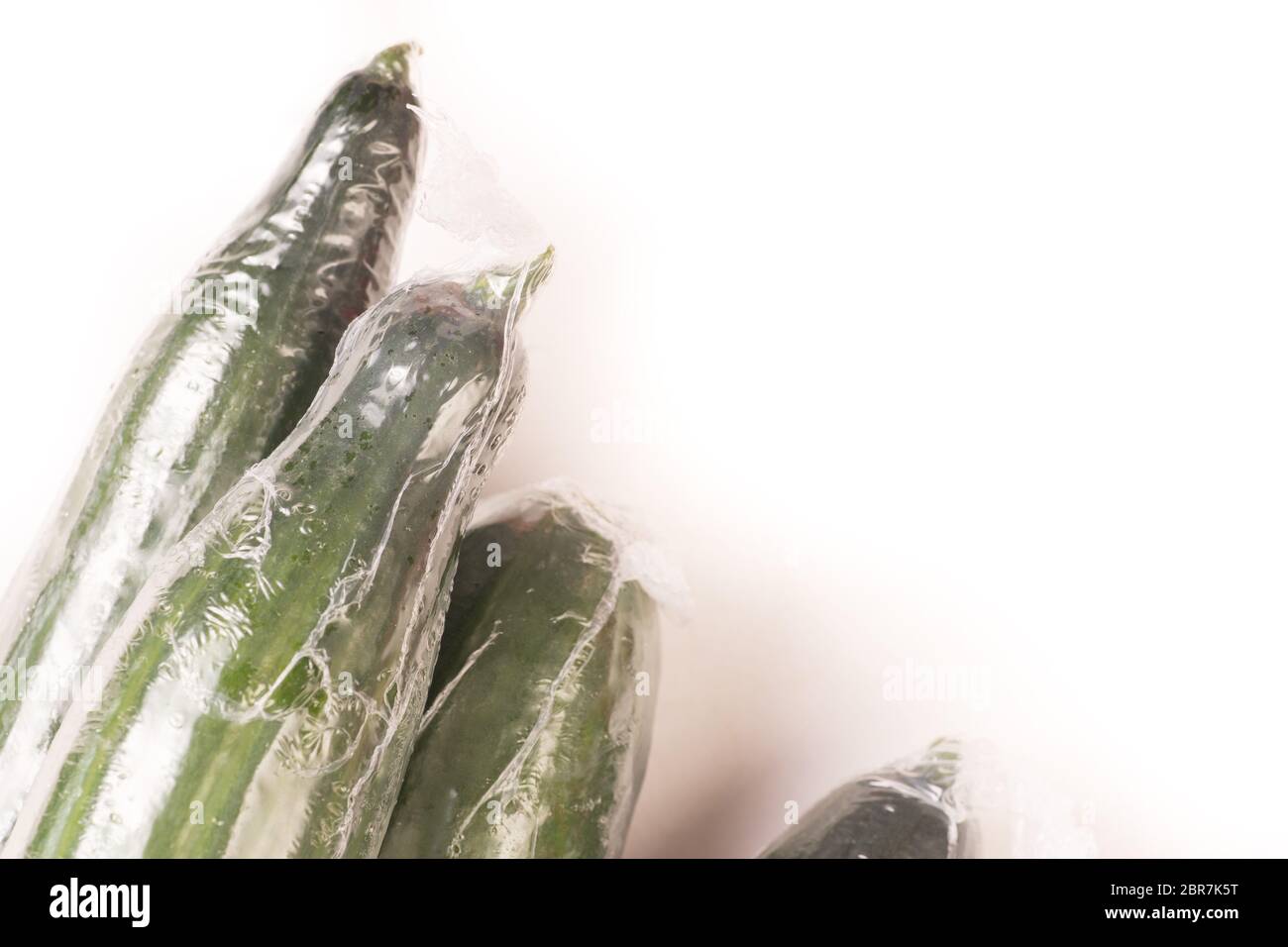 Bunch of cucumber wrapped in plastic films, isolated on white ...