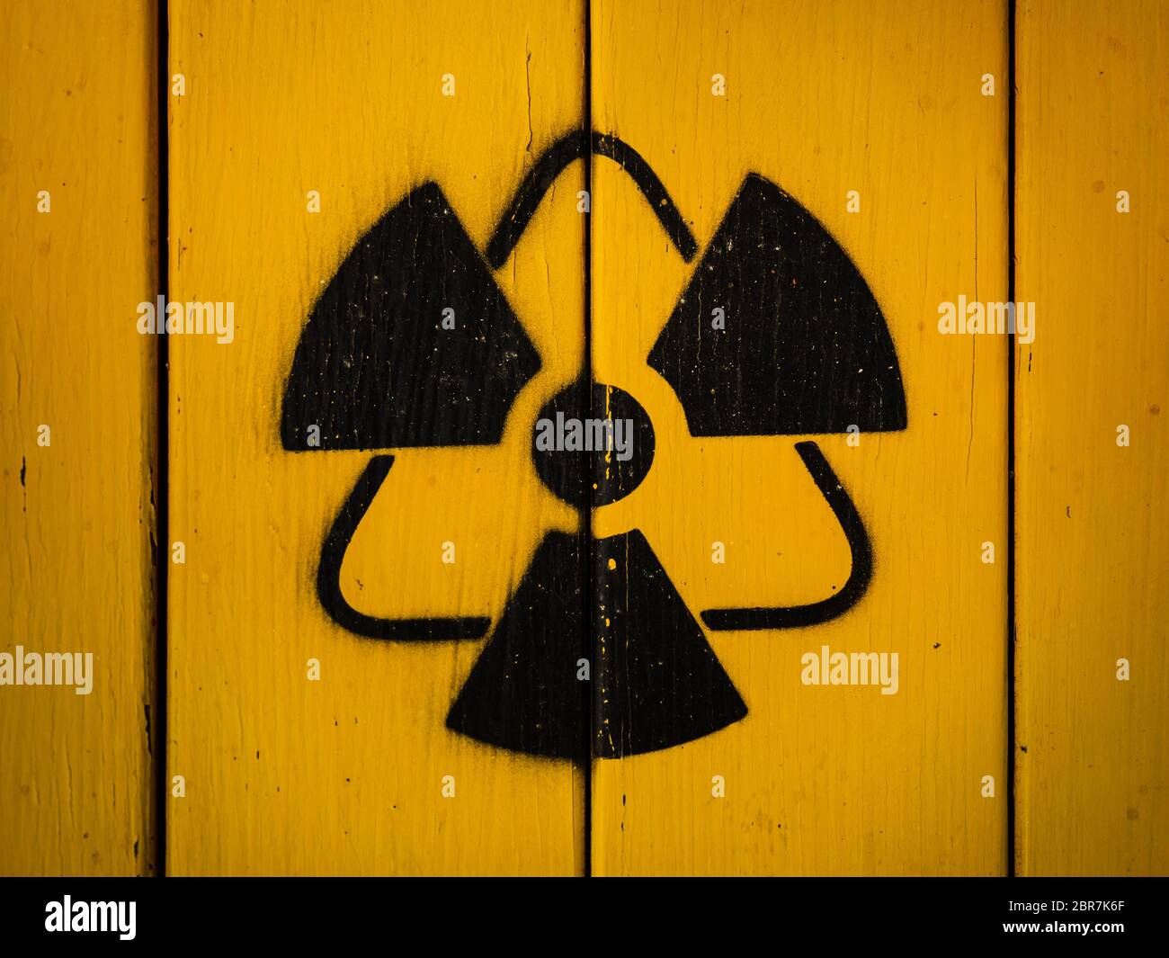 Radioactivity sign, close-up. Sign of radiation on a yellow wooden ...