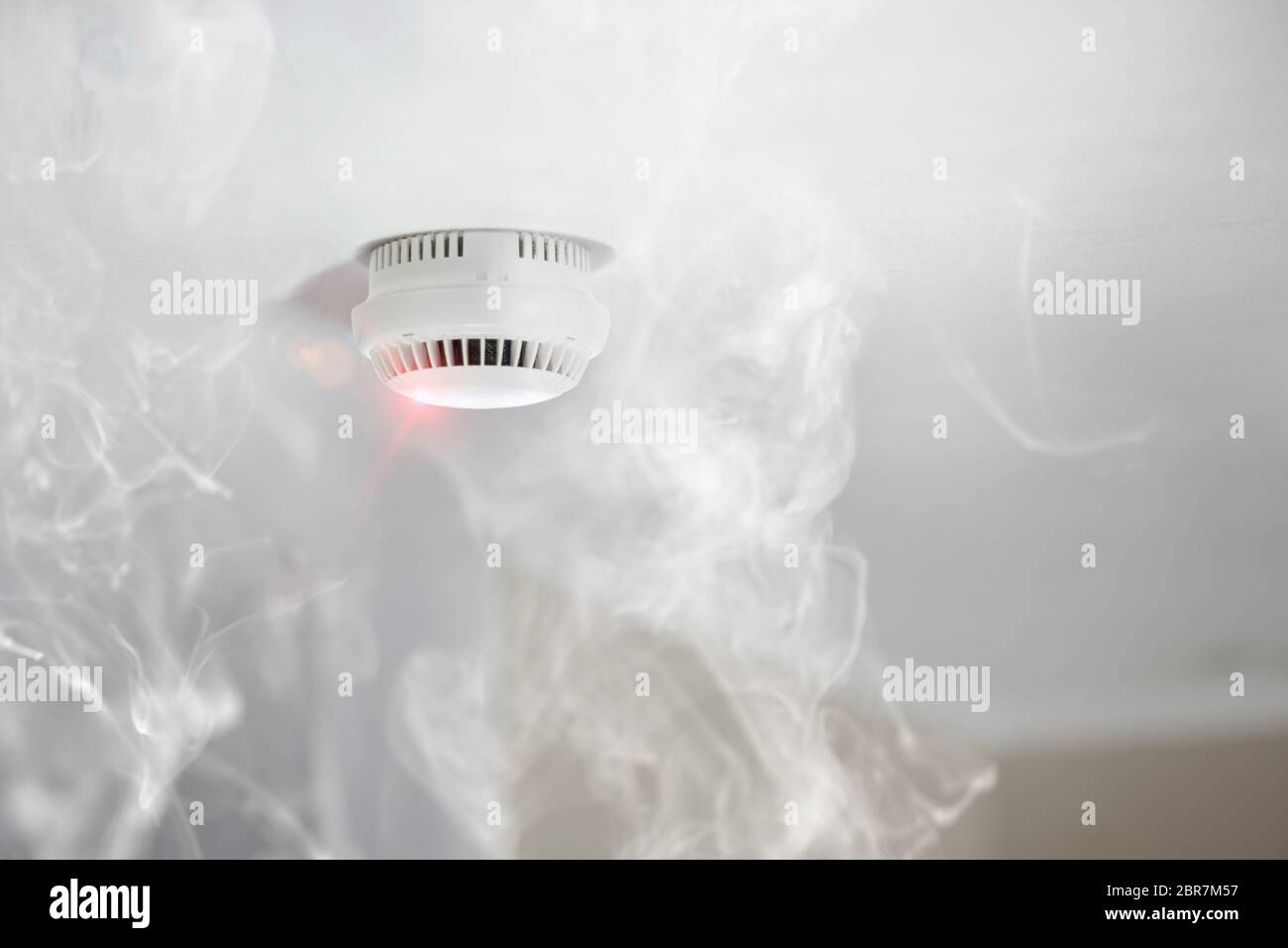 Smoke detector mounted on roof in apartment Stock Photo - Alamy