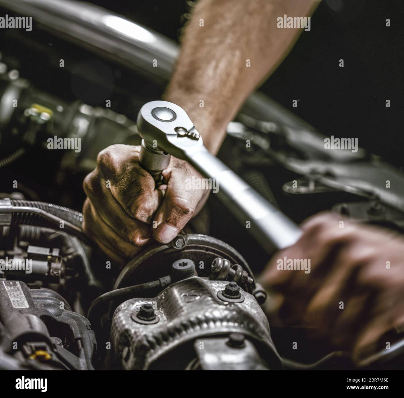 Auto mechanic working on car engine in mechanics garage. Repair service ...
