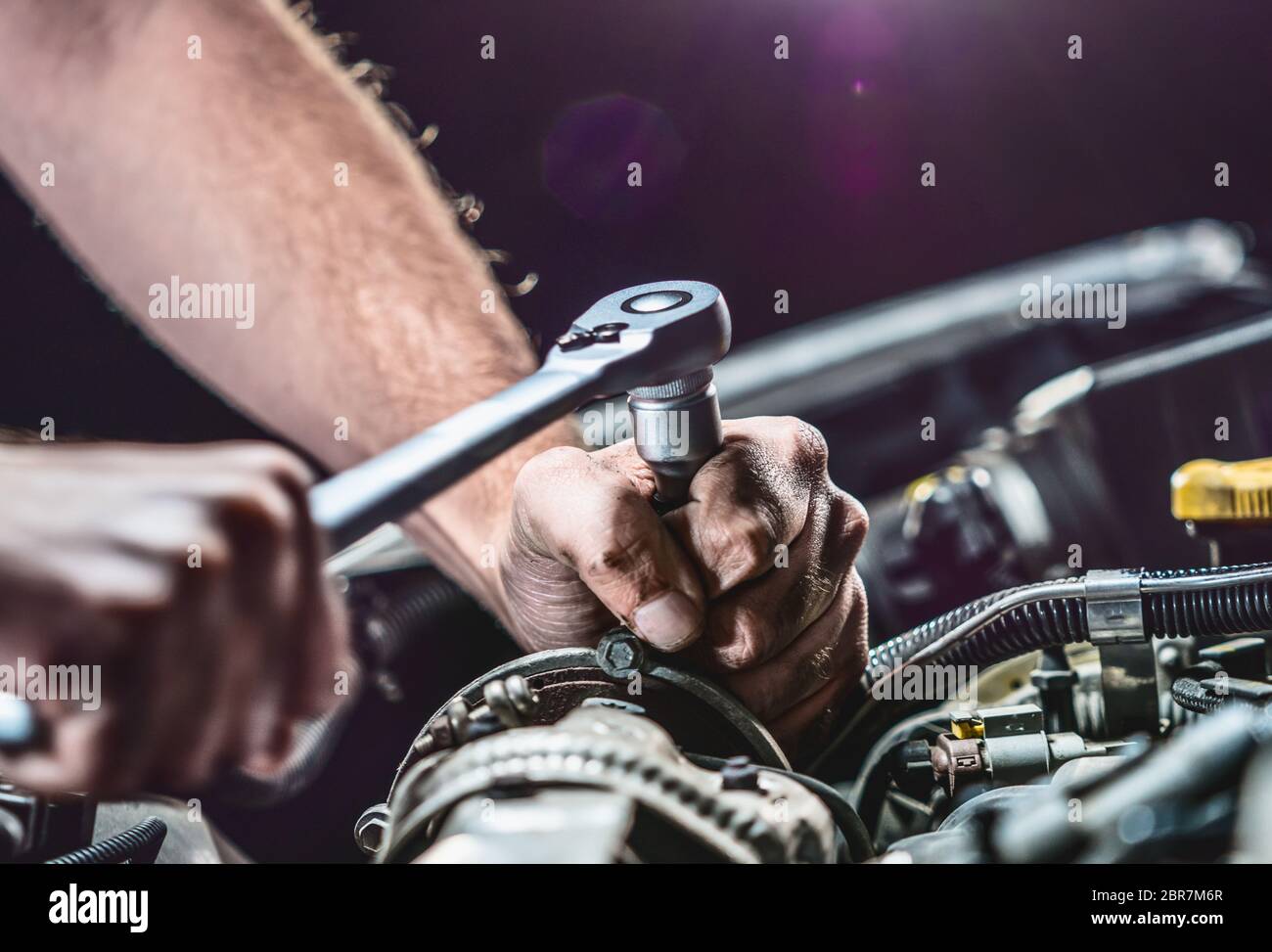 Auto mechanic working on car engine in mechanics garage. Repair service ...