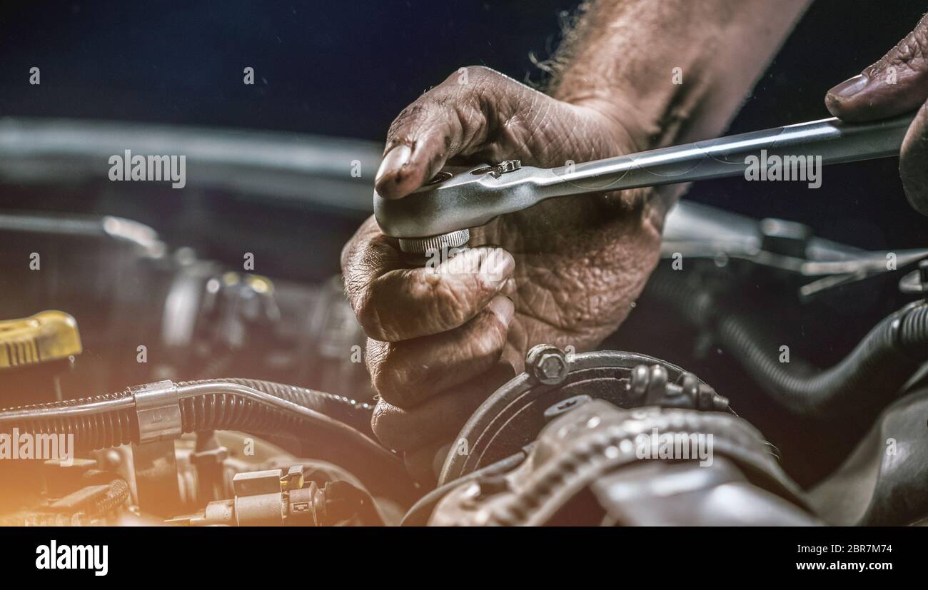 Auto mechanic working on car engine in mechanics garage. Repair service ...