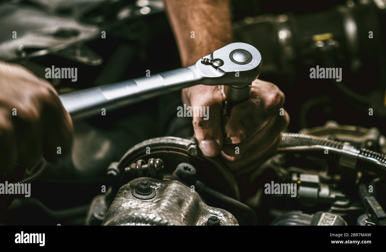 Auto mechanic working on car engine in mechanics garage. Repair service ...