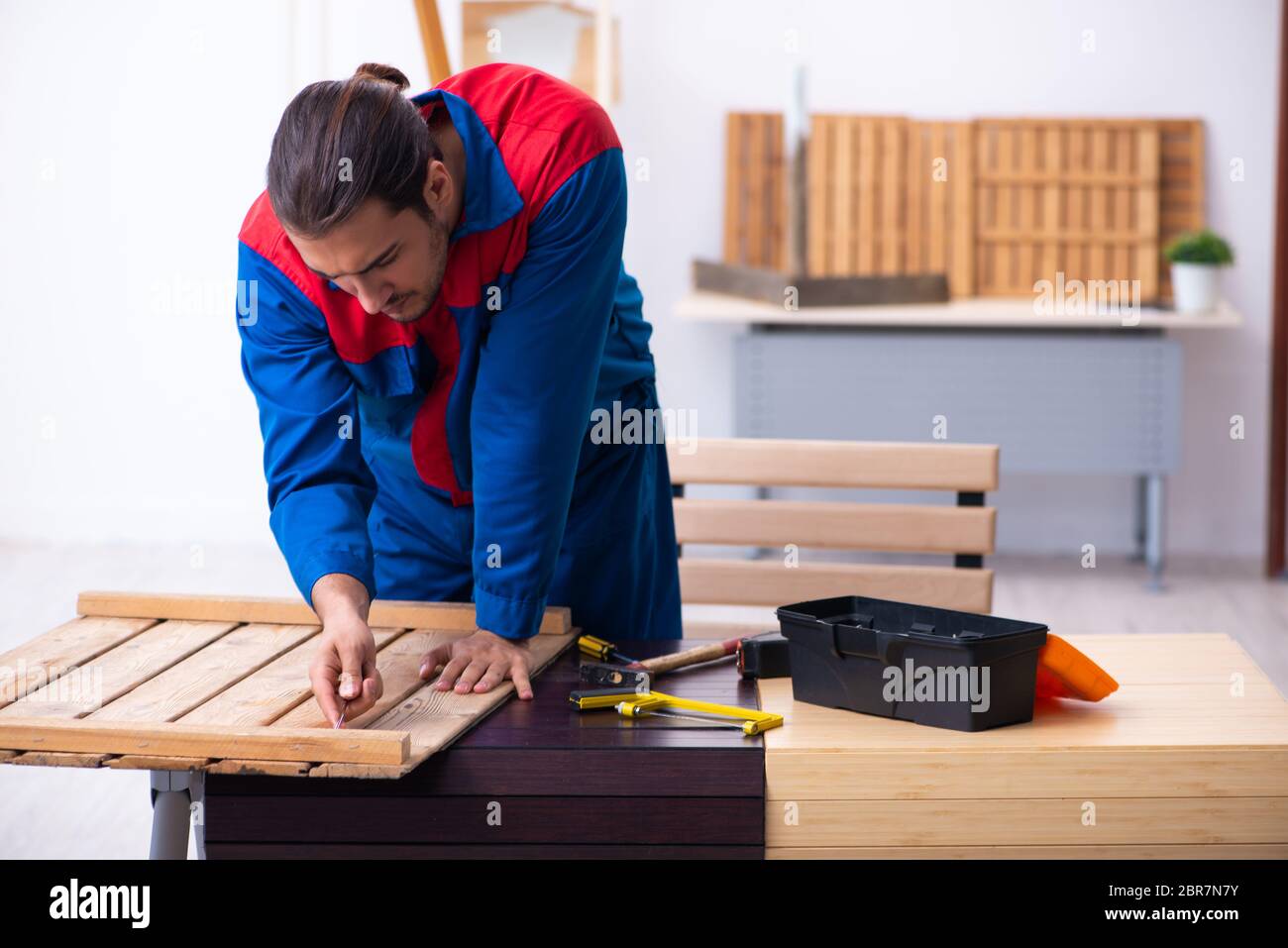 Young male contractor working in the workshop Stock Photo - Alamy