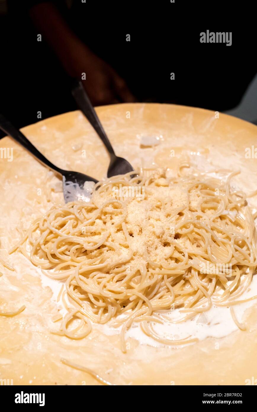 Chef cooking pasta in cheese bowl Stock Photo - Alamy