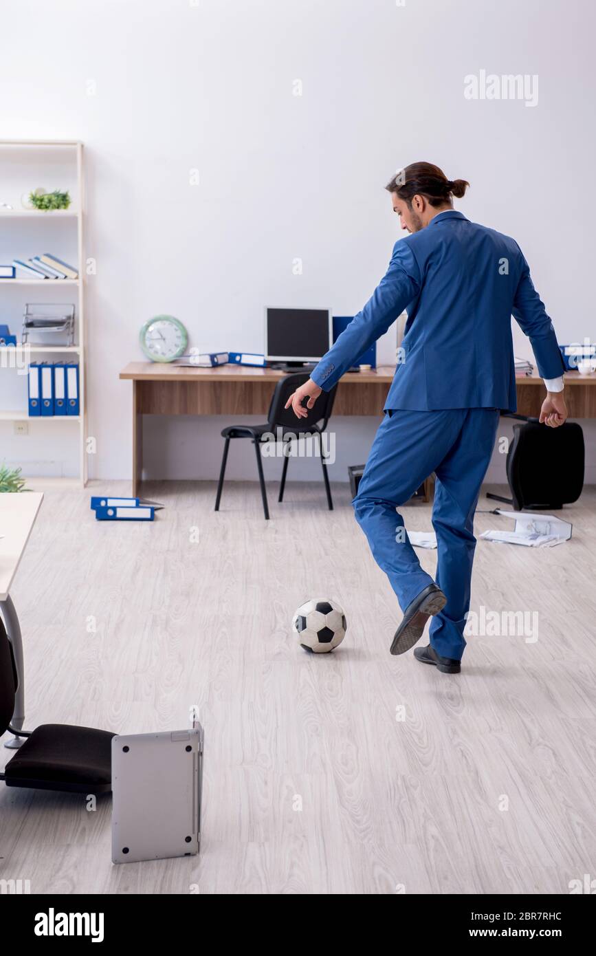 Young employee playing football in the office Stock Photo - Alamy