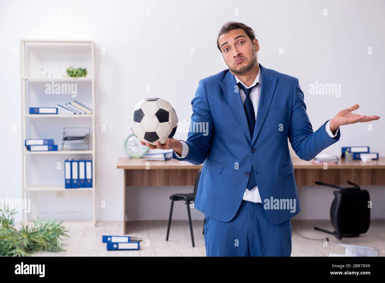 Young employee playing football in the office Stock Photo - Alamy