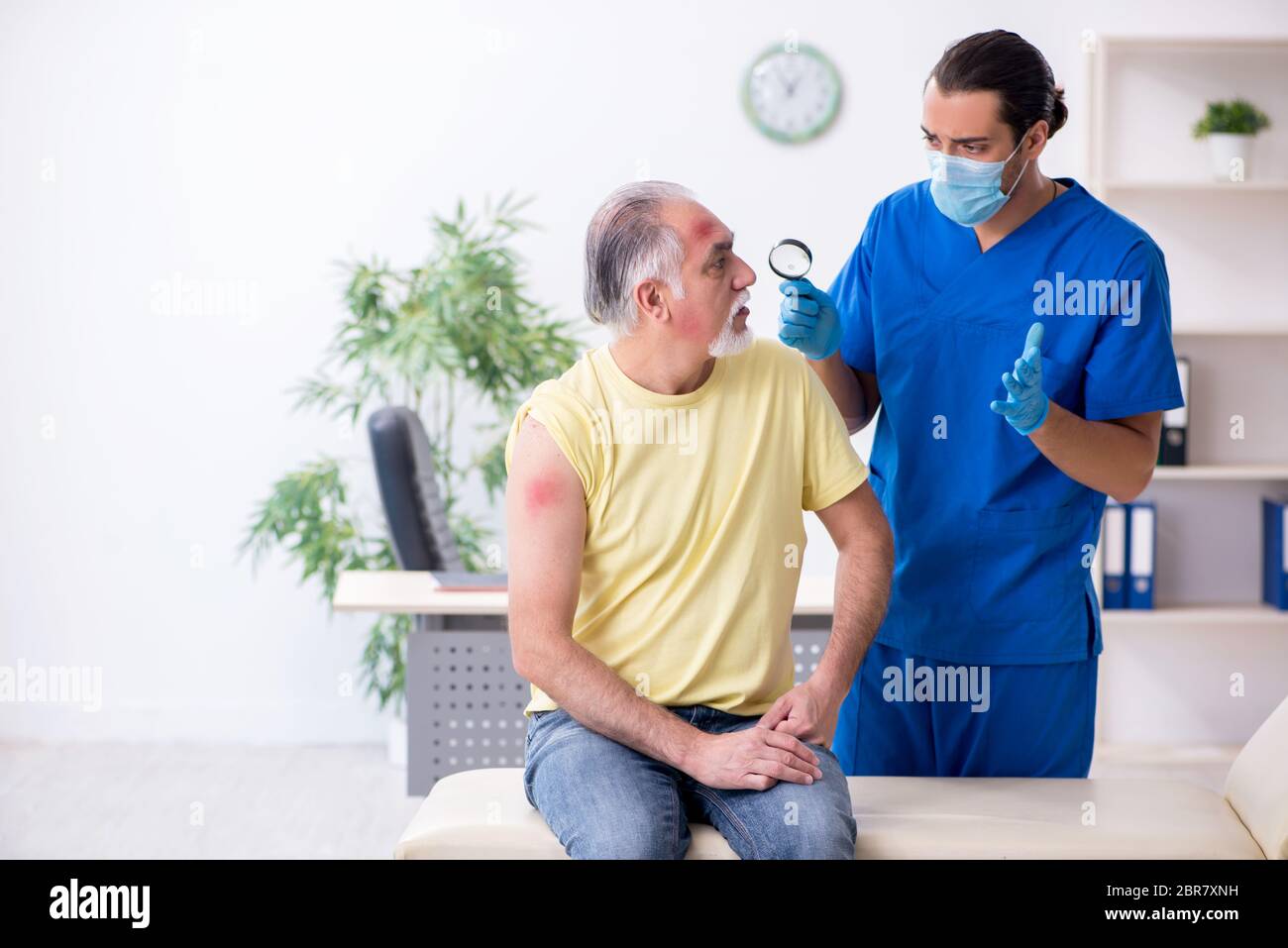 Injured old man visiting male doctor traumatologist Stock Photo - Alamy