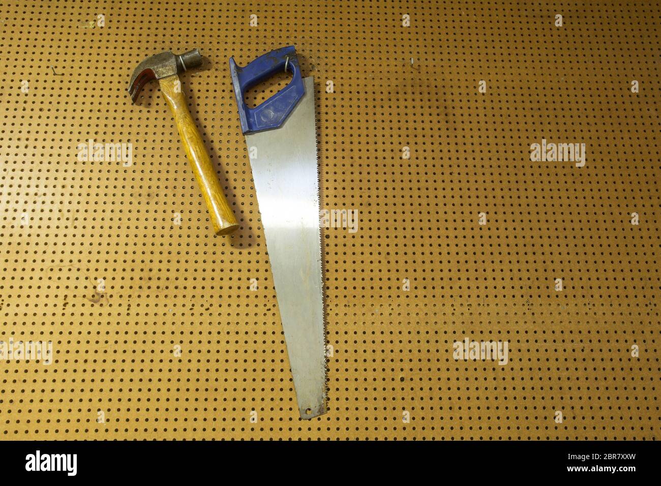 Hammer and saw on tool rack in the garage close-up Stock Photo - Alamy