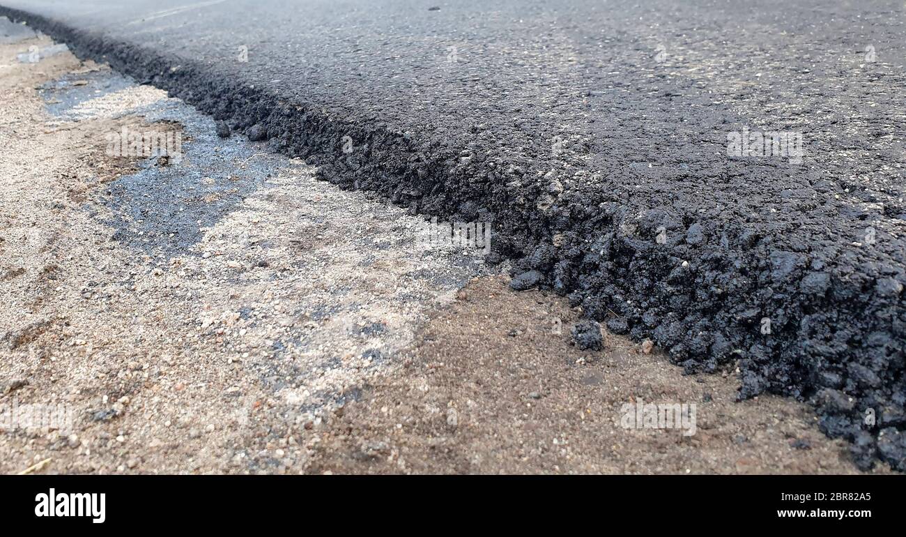Laying a layer of hot asphalt on compacted soil Stock Photo - Alamy