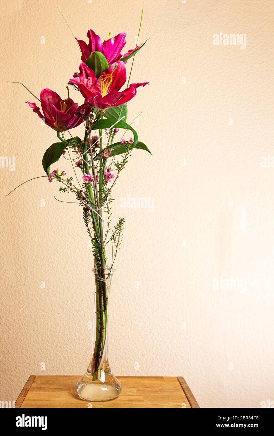 Bouguet with red lily flowers in a glass vase Stock Photo - Alamy