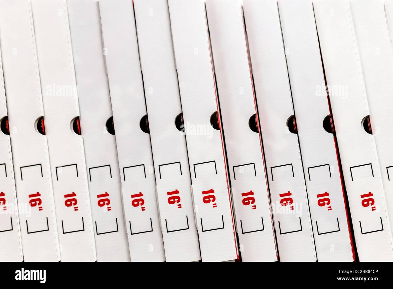 A large stack of white pizza boxes with red numbers diaimeter 16 Stock ...