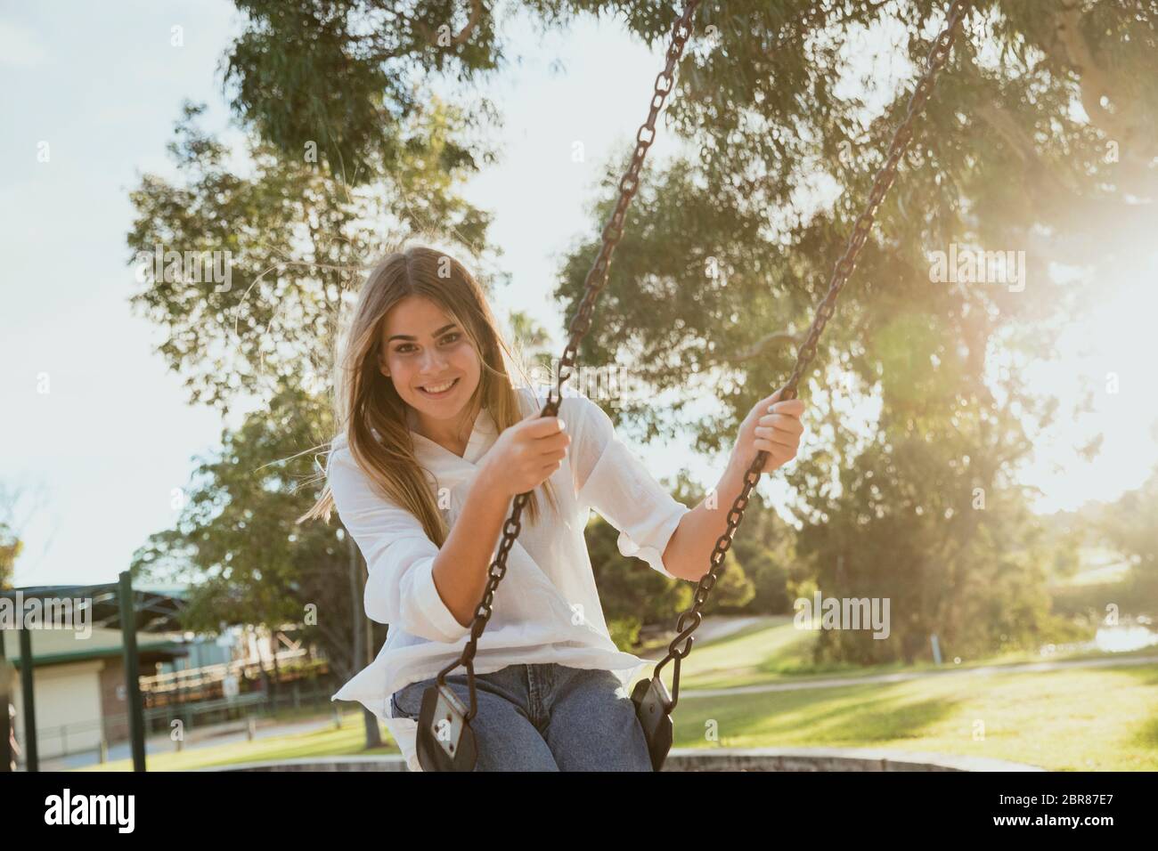 Teenage girl using a swing Stock Photo - Alamy