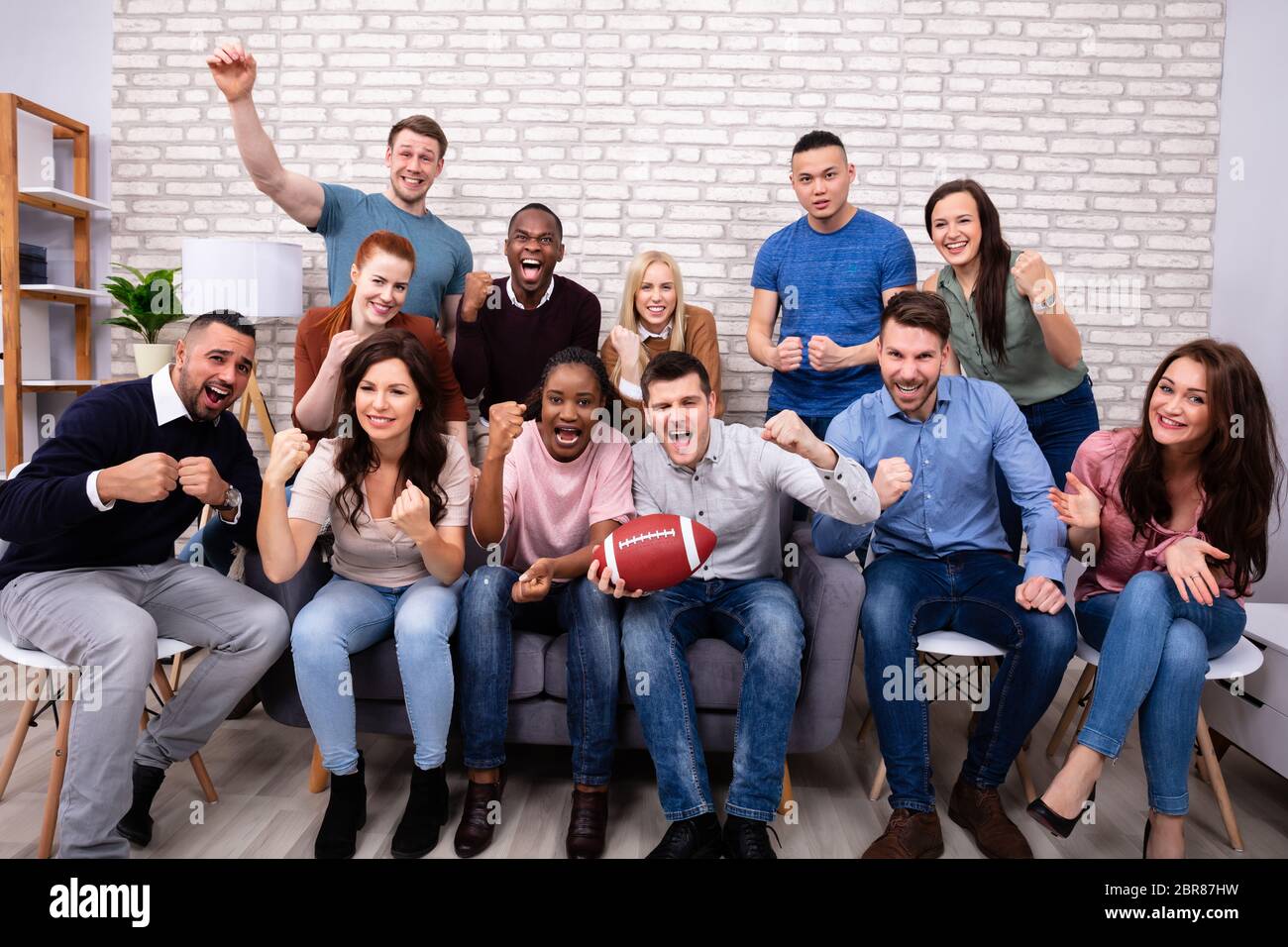 Young Friends Cheering While Watching Rugby Match At Home Stock Photo ...
