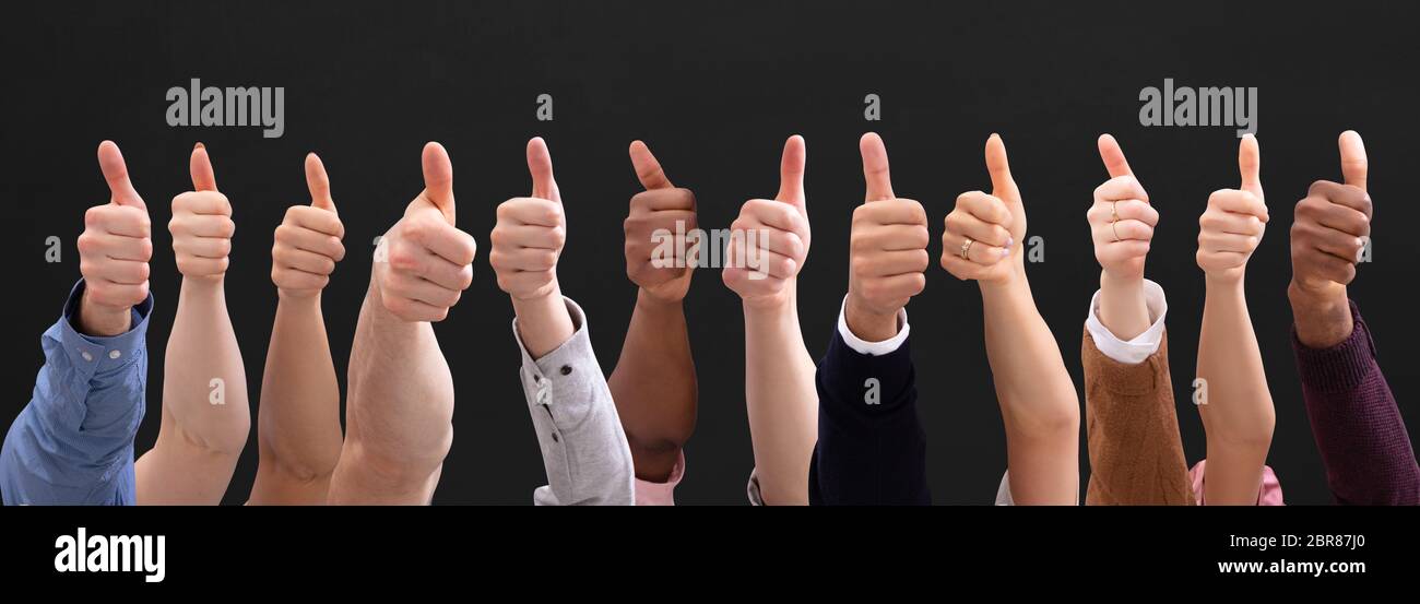 Close-up Of People's Hand Showing Thumb Up Sign Over Black Backdrop ...