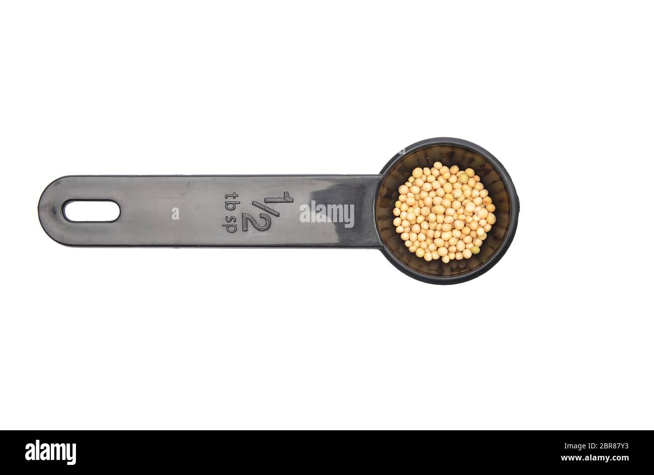 Mustard seeds in measuring spoon on white background Stock Photo - Alamy
