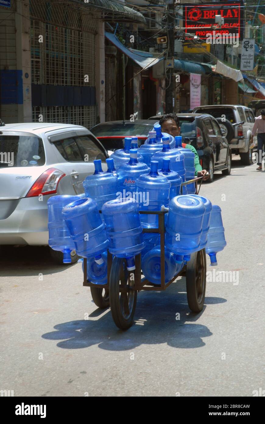 Man pushing water bottles stacked in a cart, Yangon, Myanmar, Asia ...