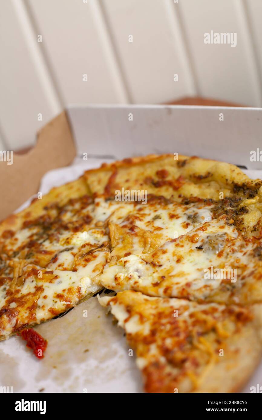 Boxed cheese pizza pie with one slice missing Stock Photo - Alamy